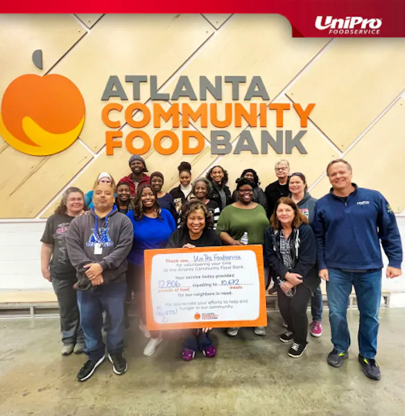 Employees holding a check at a UniPro volunteering event